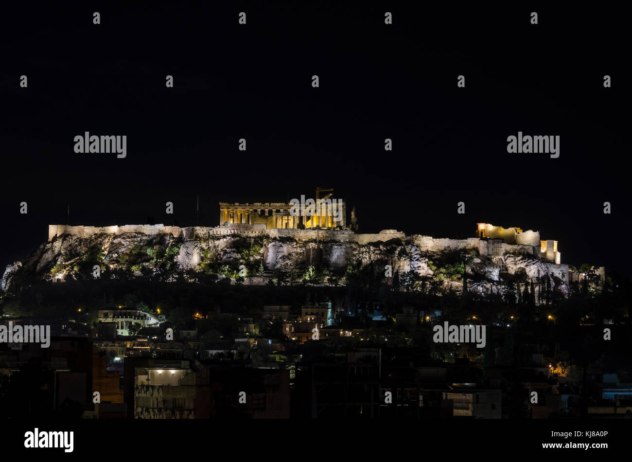 night view of the athens acropolis and modern buildings that surround ...