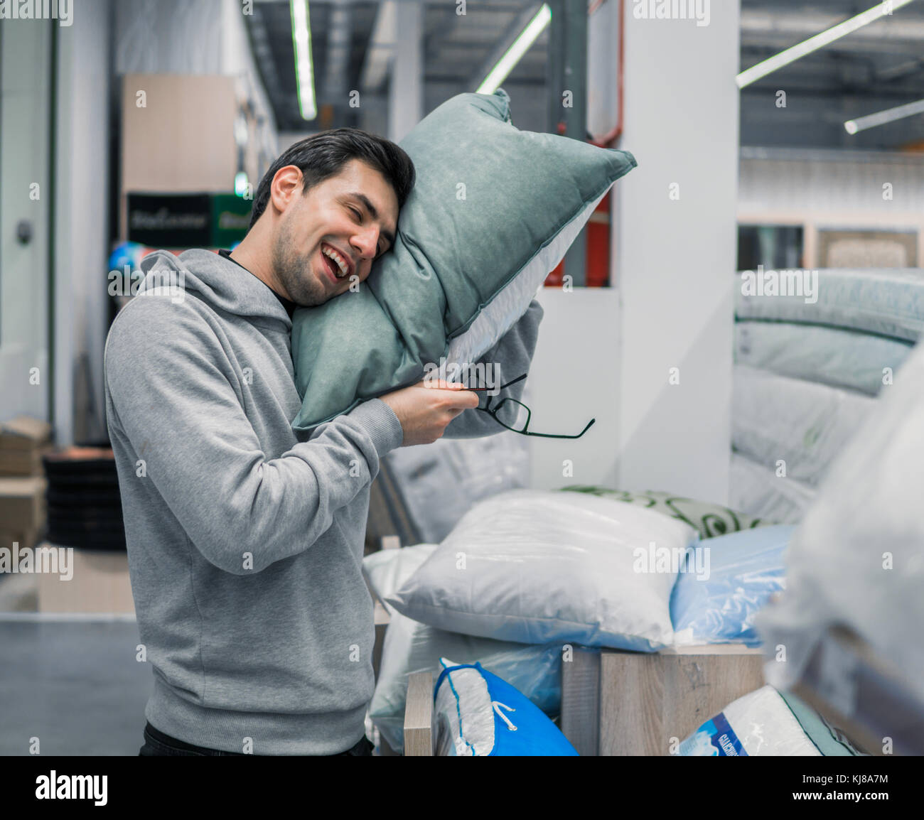 Customer man chooses pillow and linen in the supermarket Stock Photo ...