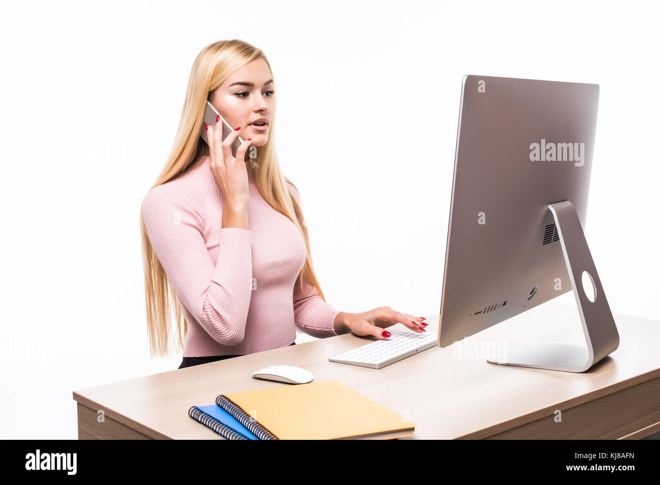Portrait of smiling blonde businesswoman phoning at her desk in office ...
