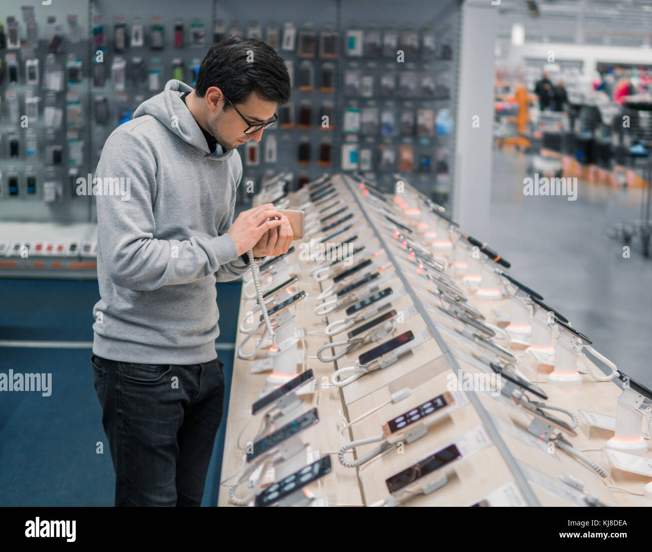 Smart male customer choosing smartphone Stock Photo - Alamy