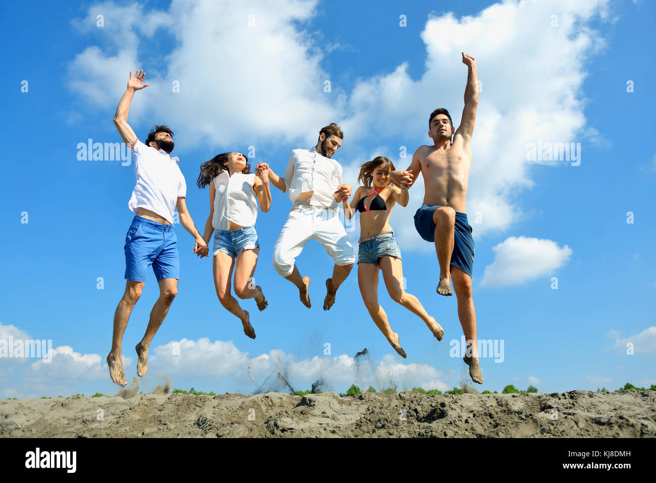Image of young people jumping together outdoor Stock Photo - Alamy
