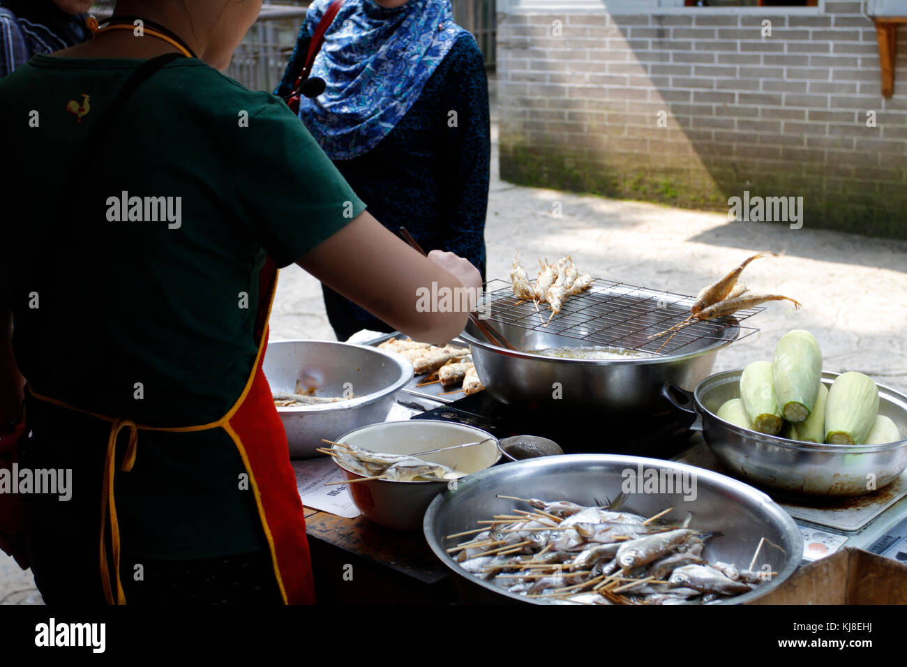 Selling foodstuff to Muslim woman in Gulin, China Stock Photo - Alamy