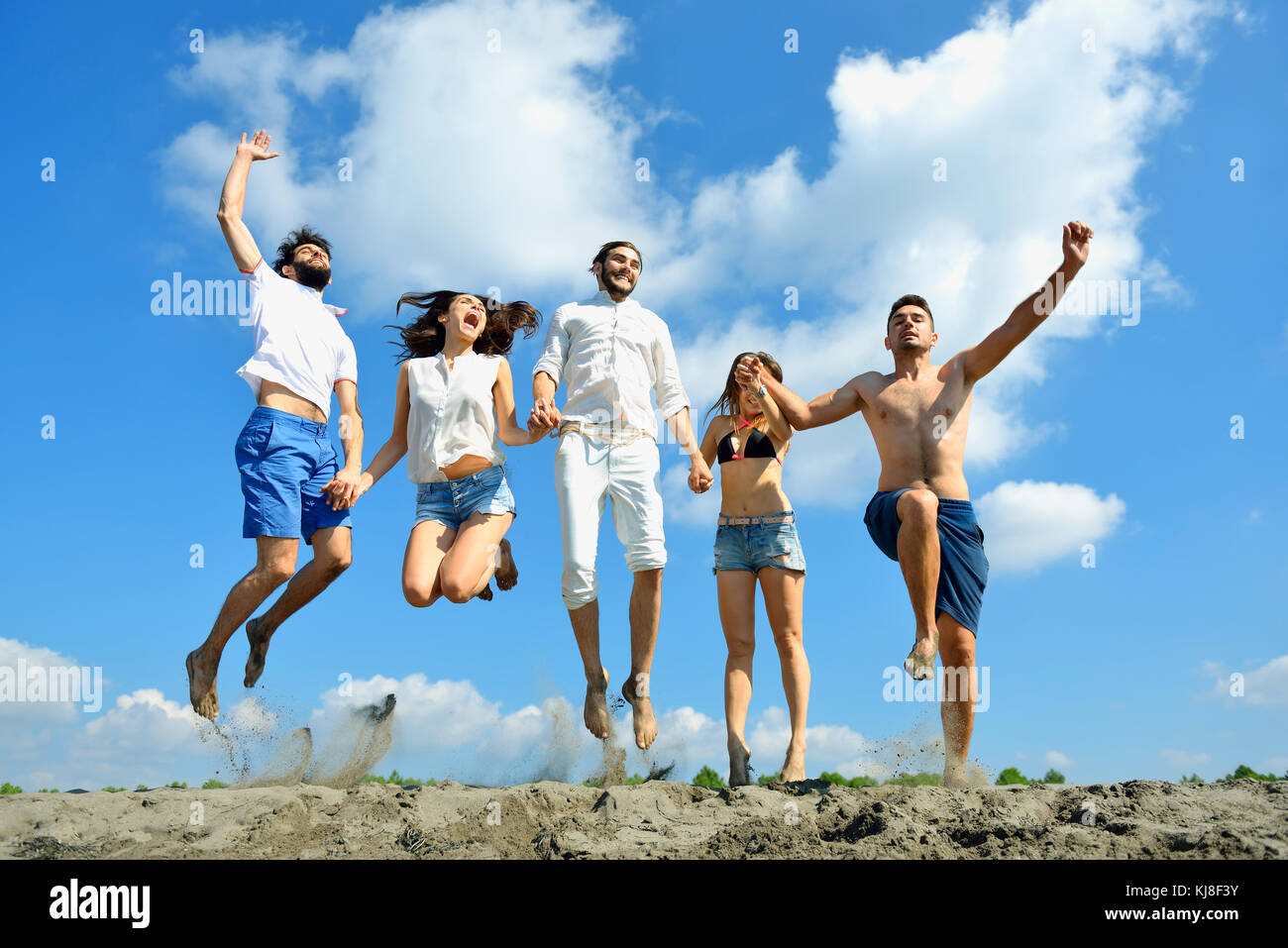 Image of young people jumping together outdoor Stock Photo - Alamy