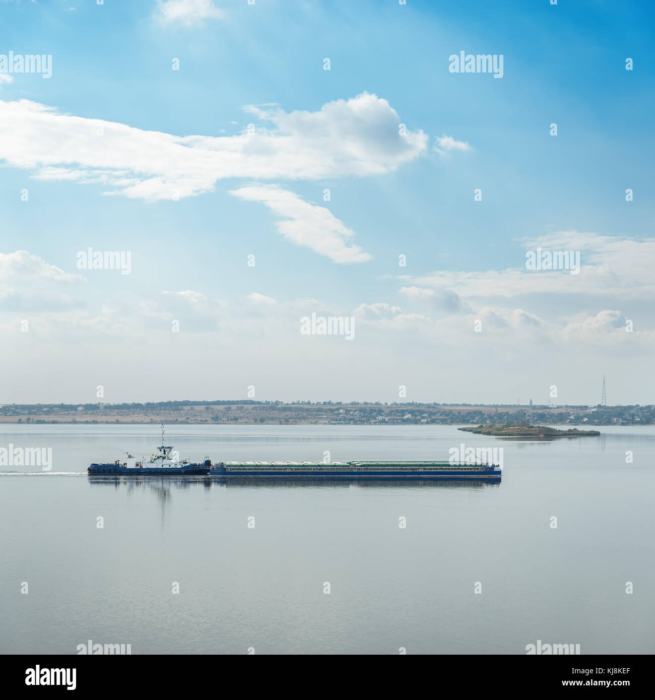 barges with boat on river and clouds in blue sky Stock Photo - Alamy