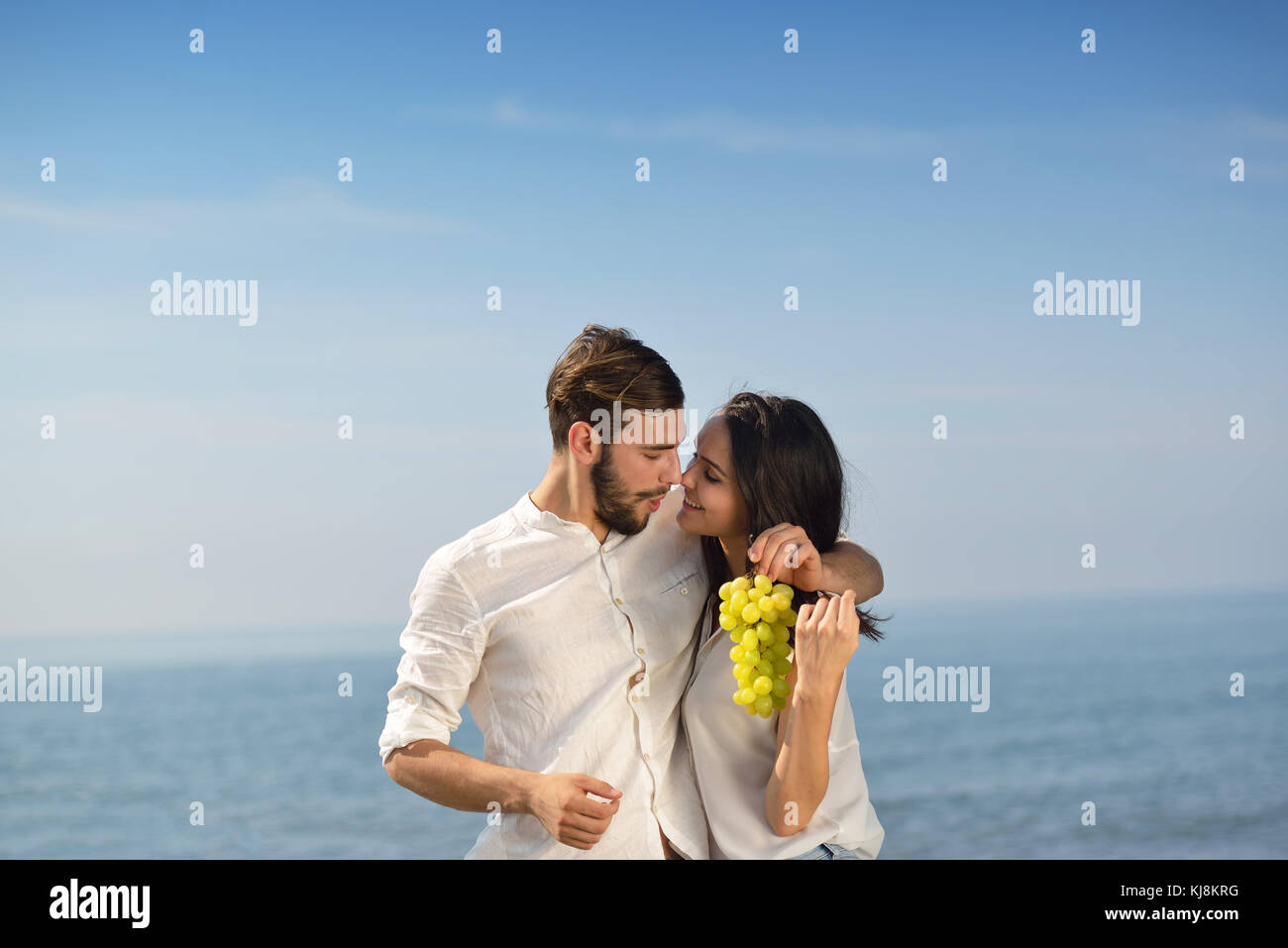 Young happy couple having date on seashore Stock Photo - Alamy