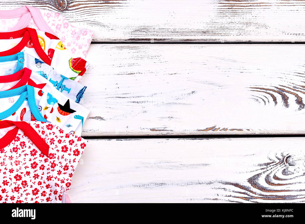 Baby cute garment, wooden background. Cotton patterned clothes for ...