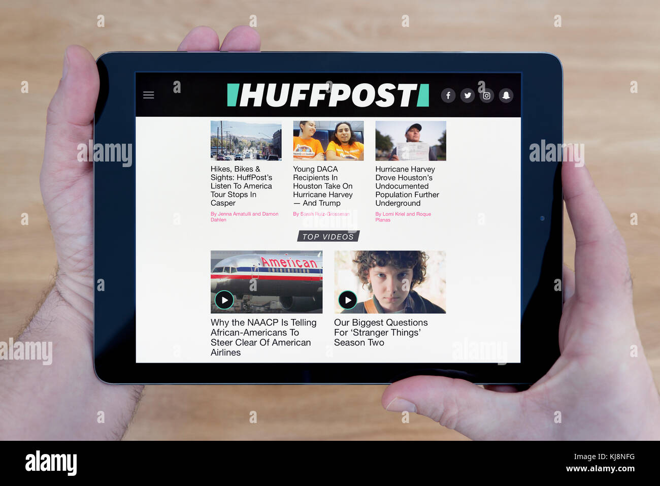 A man looks at the Huffington Post website on his iPad tablet device ...