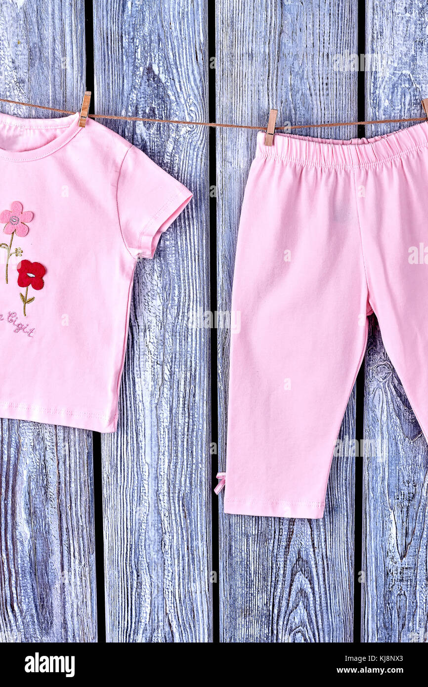 Little girl pink garment on rope. Baby-girl cotton casual suit hanging ...