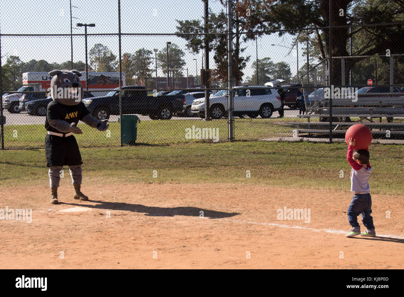 Sgt. Rocky, 3rd Infantry Division's mascot, plays ball with a young boy ...