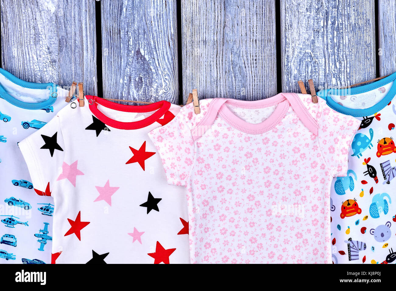 Kids fashion apparel hanging on rope. Collection of infants rompers ...