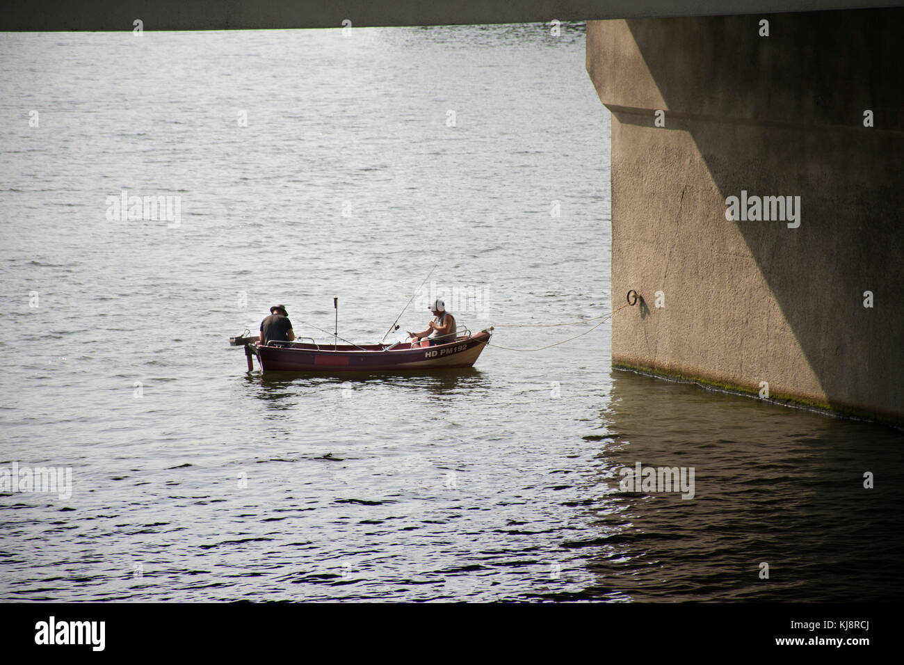 German people fishing and angling in Neckar River under bridge ...
