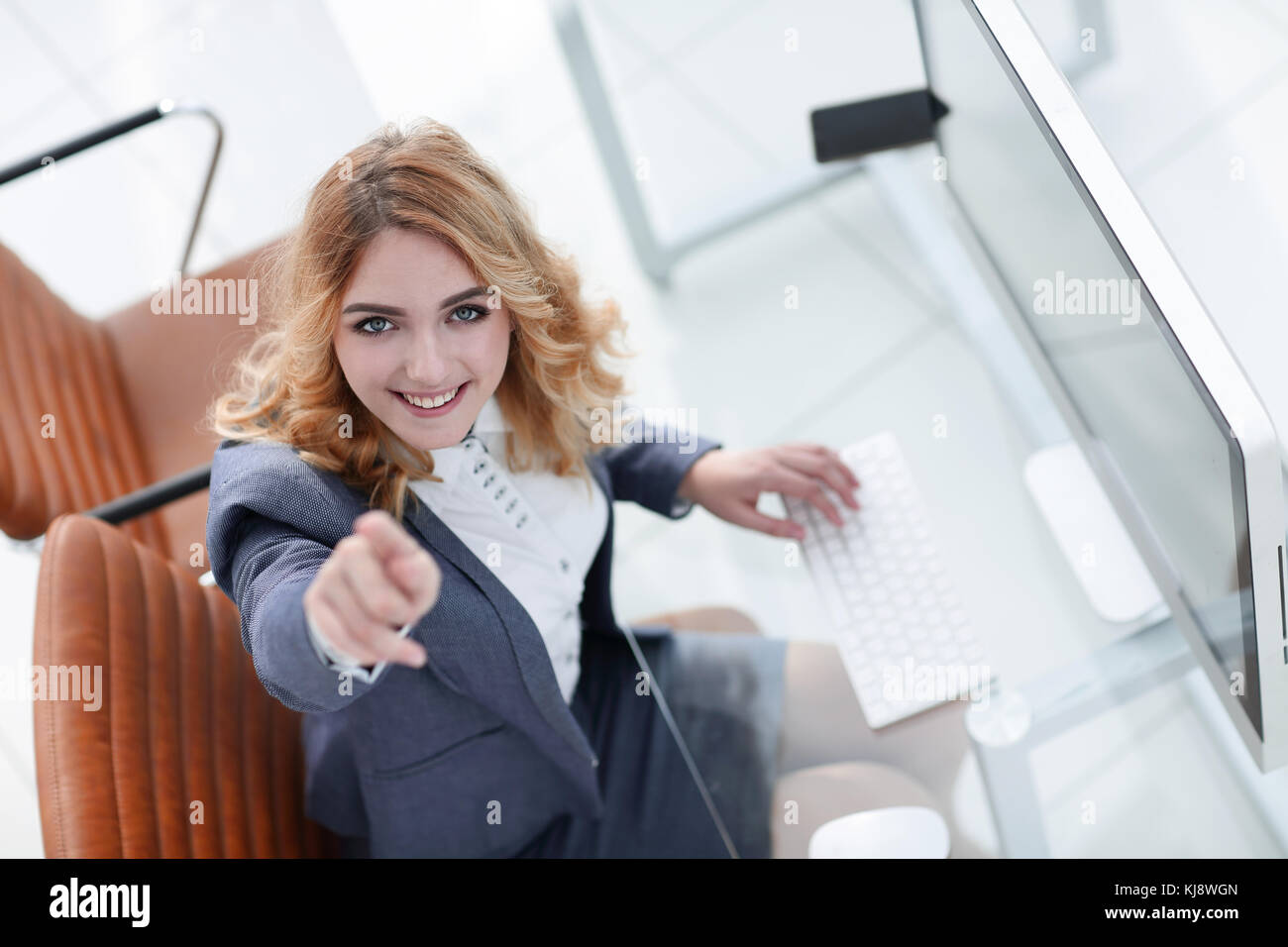 business woman pointing forward,sitting behind a Desk Stock Photo - Alamy