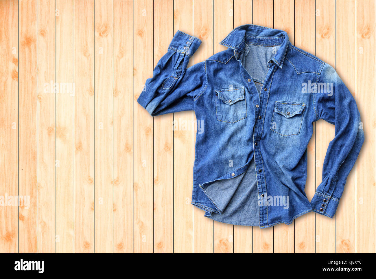 Top view of blue denim jeans shirts put on brown wooden table ...