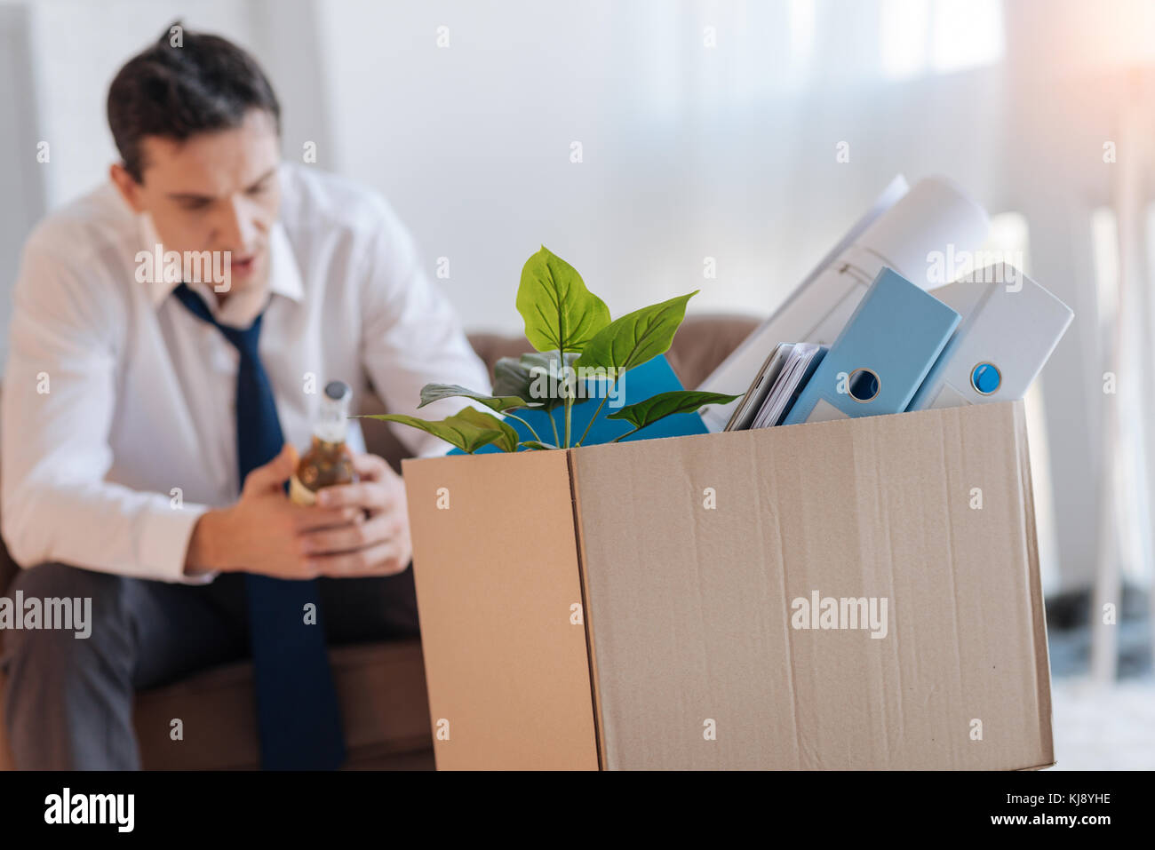 Big carton box standing in front of a depressed man Stock Photo - Alamy