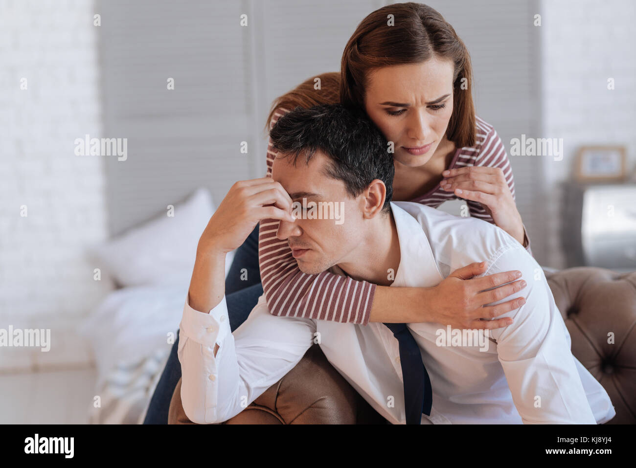 Kind loving woman hugging her exhausted depressed husband Stock Photo ...