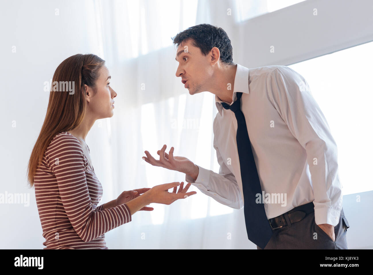 Irritated angry man giving arguments to his emotional wife Stock Photo ...