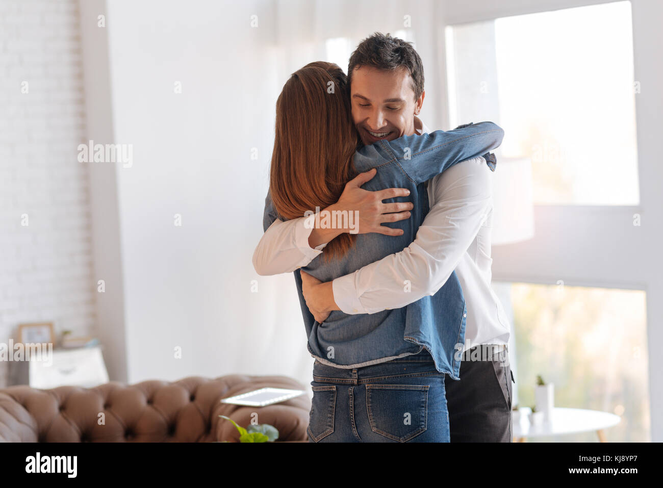 Cheerful emotional man greeting his wife with a promotion at work Stock ...