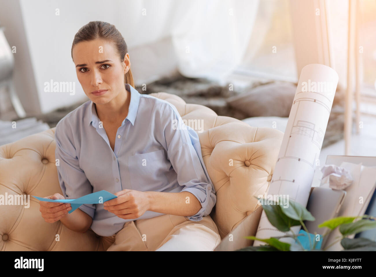 Emotional fired woman almost crying while sitting and reading Stock ...