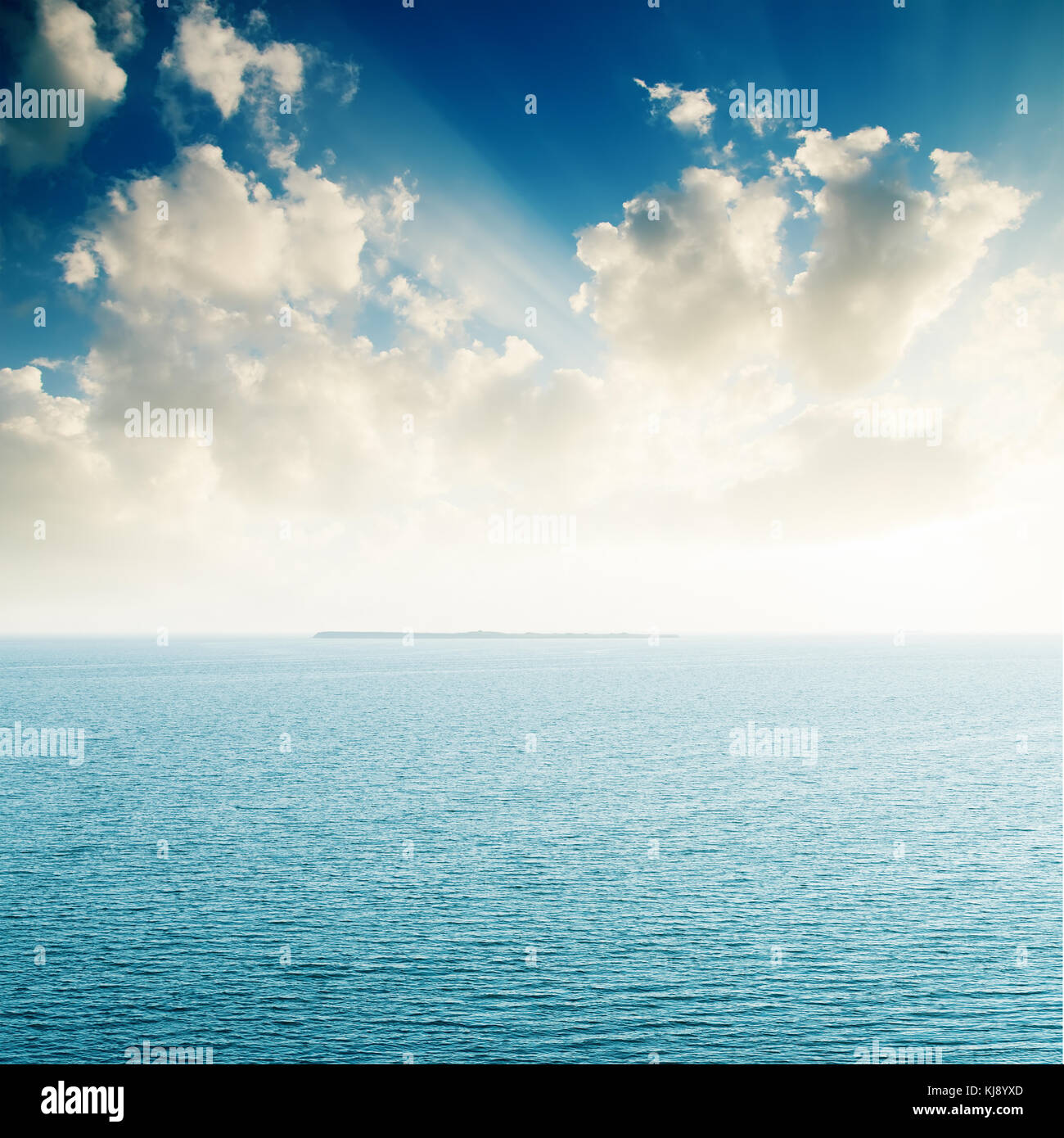 sunset in clouds over blue sea Stock Photo - Alamy