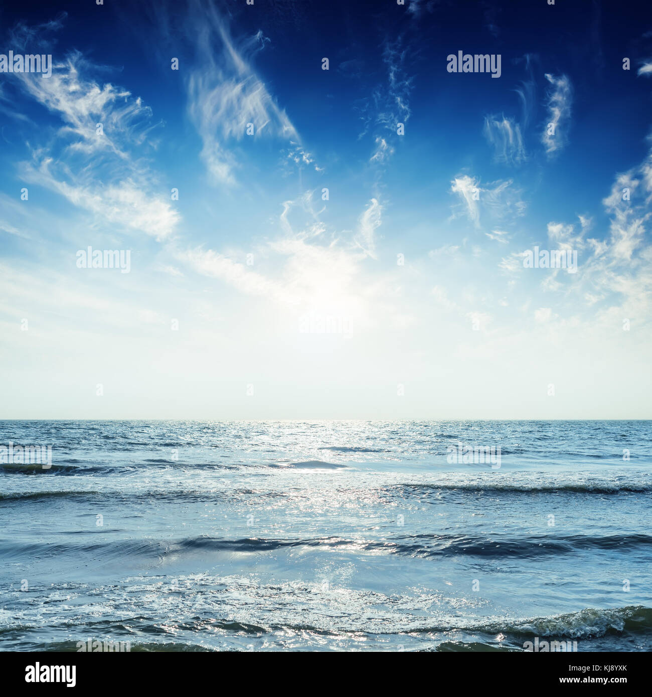 sunset in deep blue sky with clouds over sea Stock Photo - Alamy