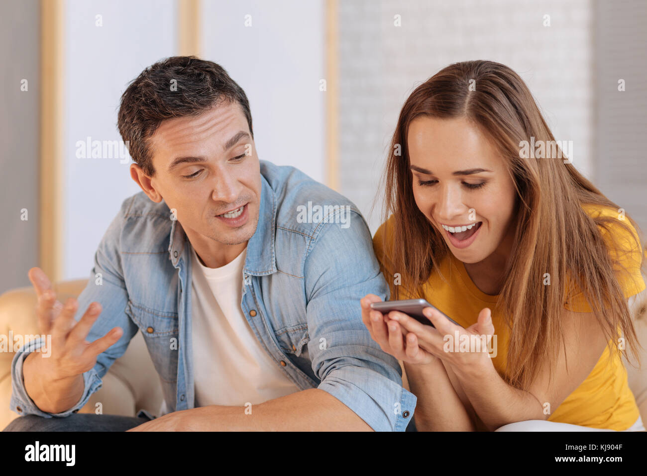 Excited young woman looking at her new wonderful gadget Stock Photo - Alamy