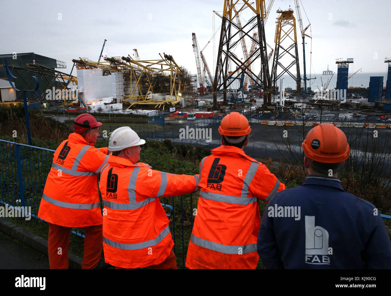 Work continues on wind turbine jackets as workers look from a viewing ...