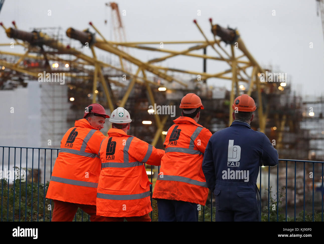Work continues on wind turbine jackets as workers look from a viewing ...