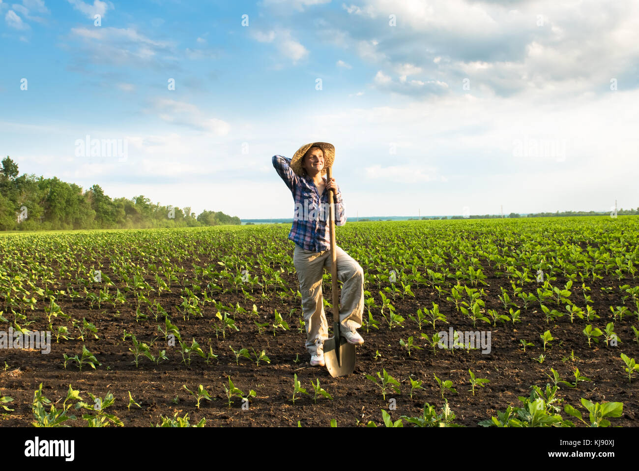 Happy small farmer with spade in spring field Stock Photo - Alamy