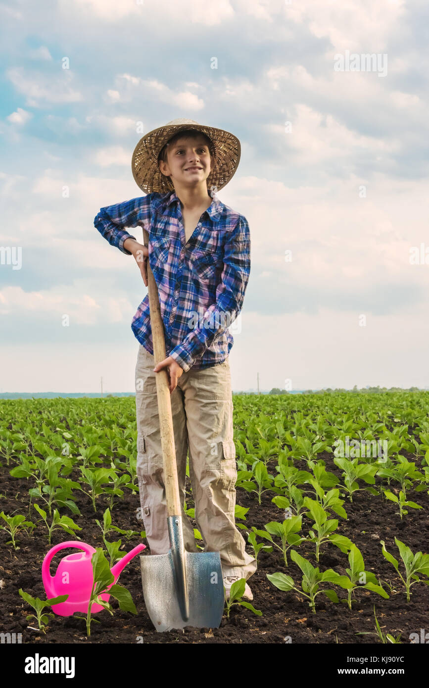 Happy small farmer with spade in spring field Stock Photo - Alamy