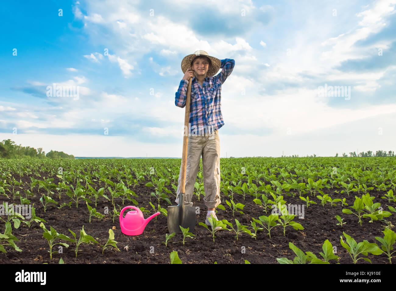 Happy small farmer with spade in spring field Stock Photo - Alamy