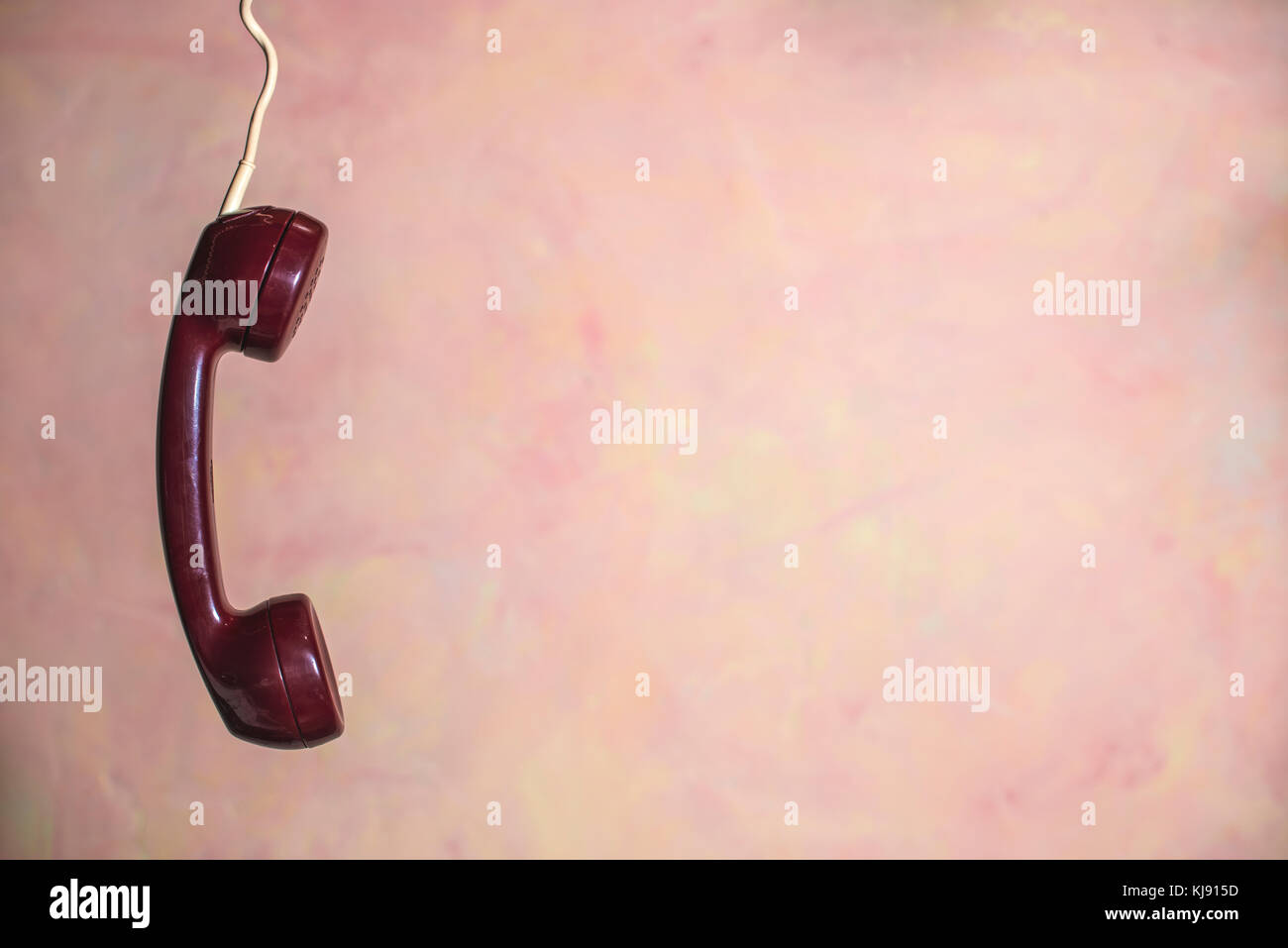 Red phone handset and pink wall background Stock Photo - Alamy