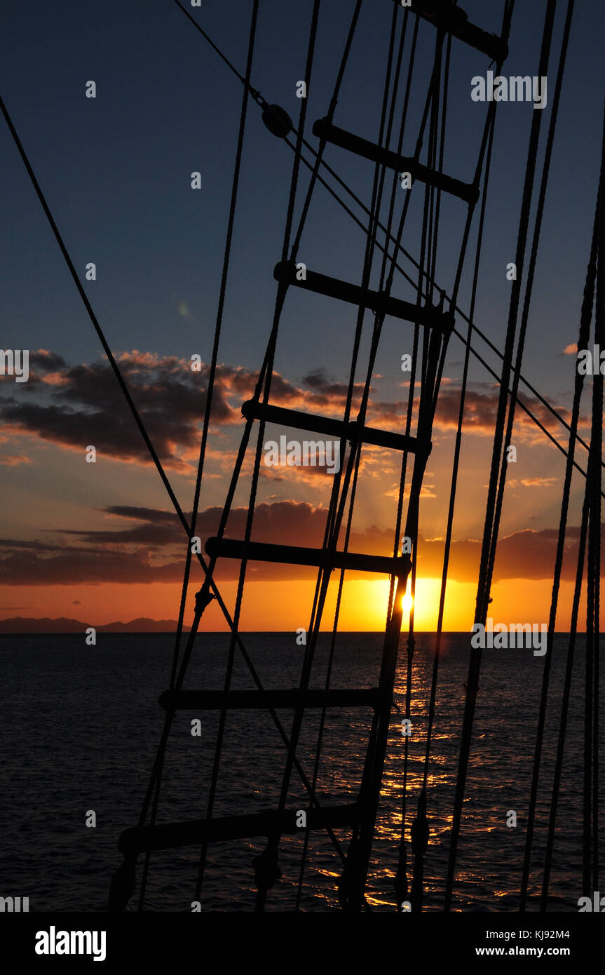 Looking through the rigging on a sailing boat at the setting sun in the ...