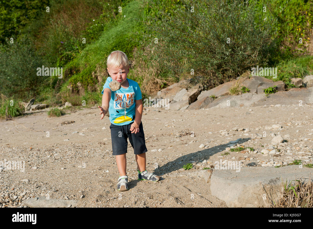 Boy throwing stones into Danube river, Austria Stock Photo - Alamy