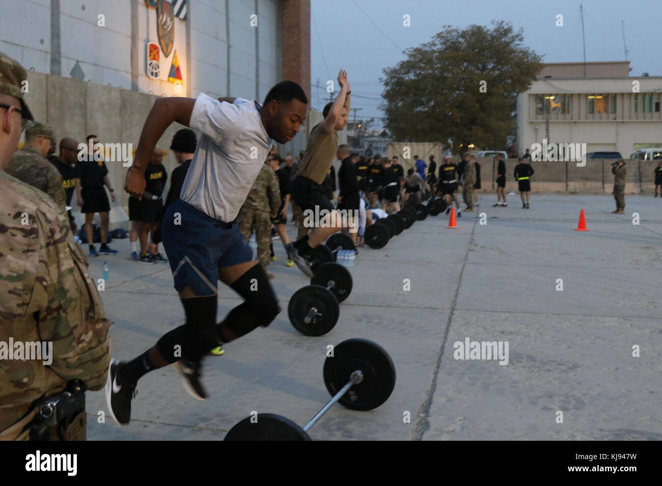 BAGRAM AIRFIELD, Afghanistan - Servicemembers leap over barbells during ...