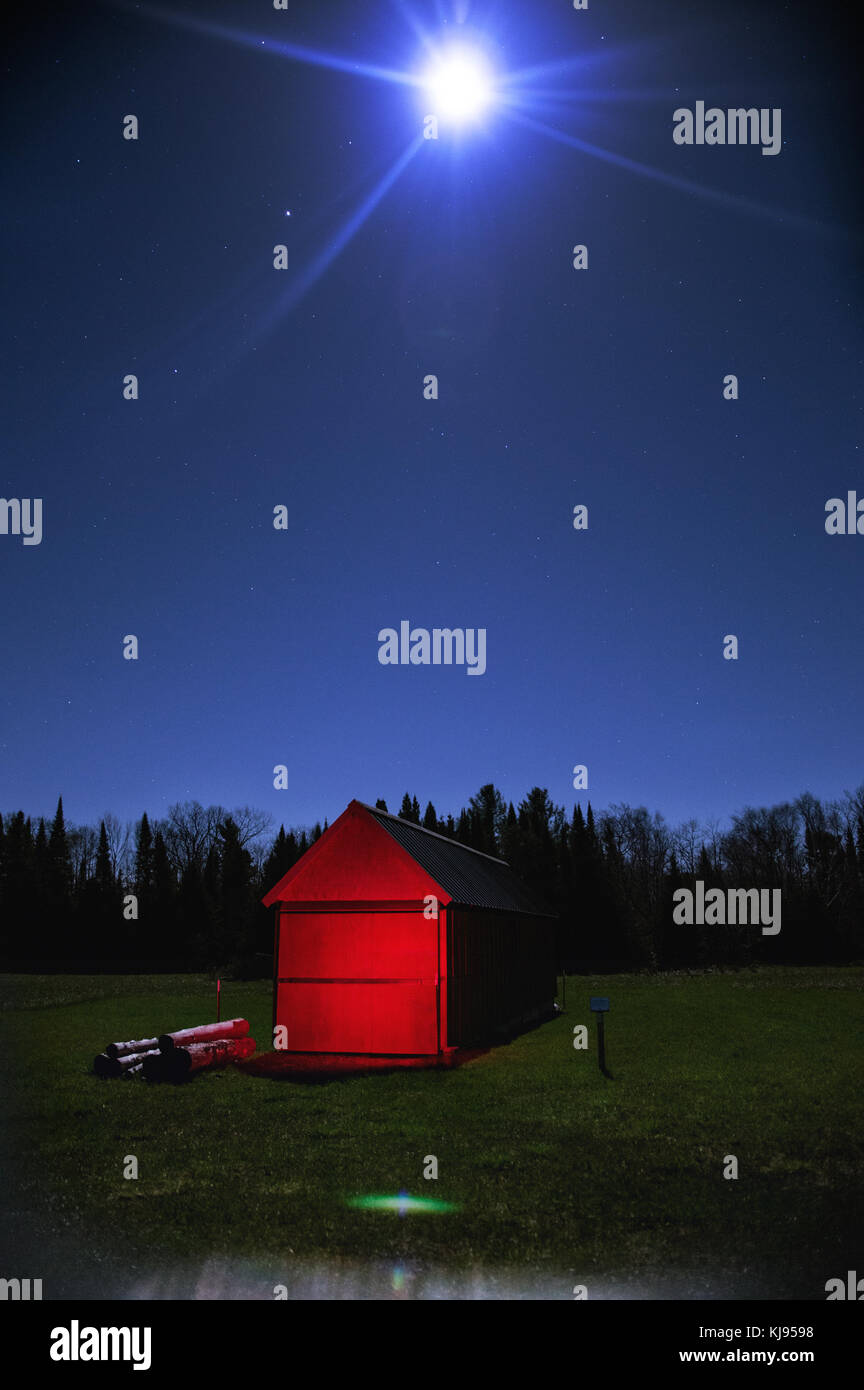 Red barn lit up against a full moon at night, Michigan, USA Stock Photo ...