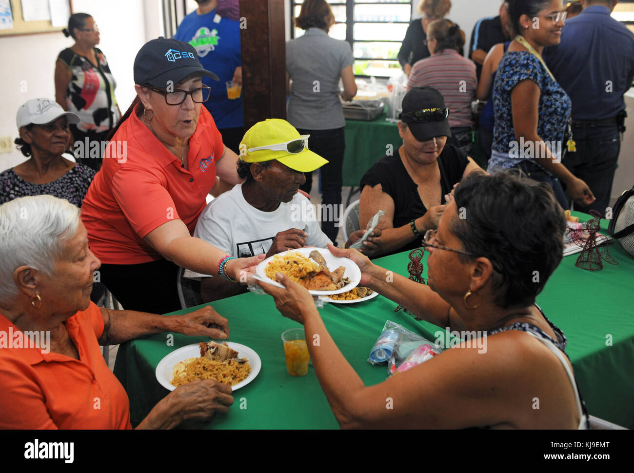 Volunteer Aileen Lopez hands out plates filled with traditional Puerto ...