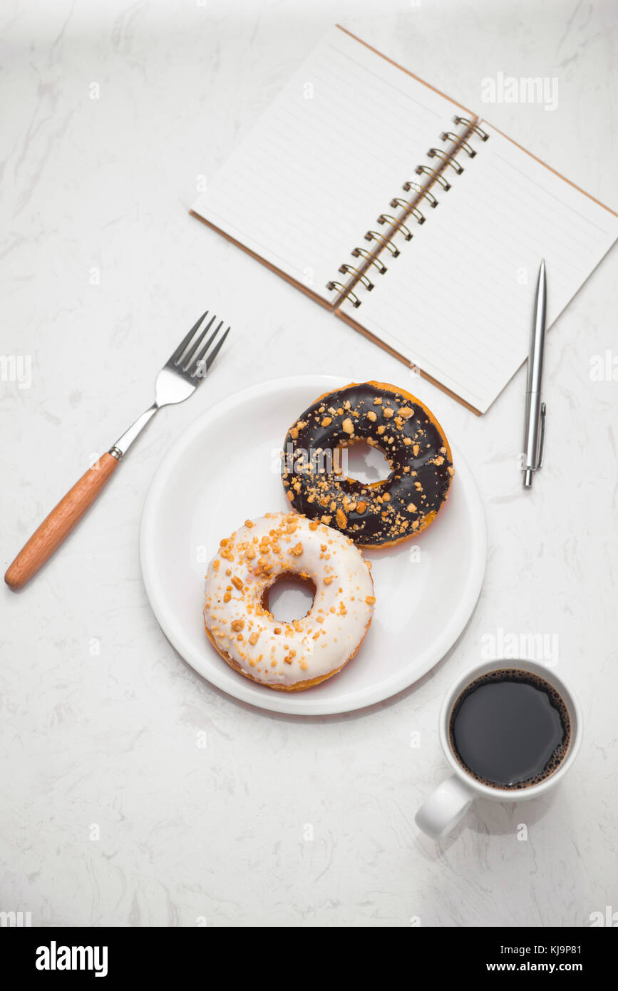 Notepad, donuts and coffee cup on table. Top view with copy space Stock ...