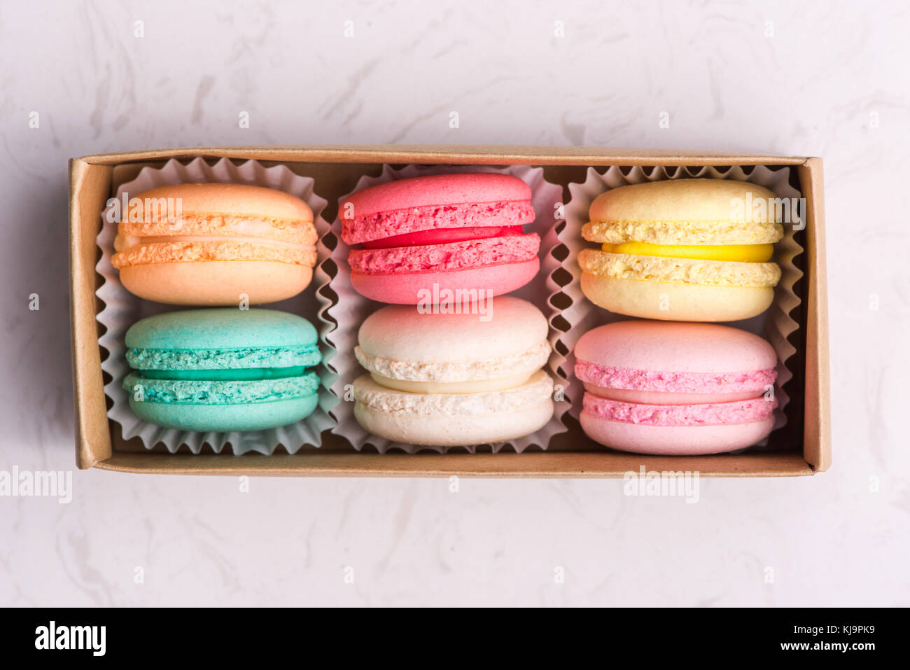 Set of different french cookies macaroons in a paper box. Top view ...