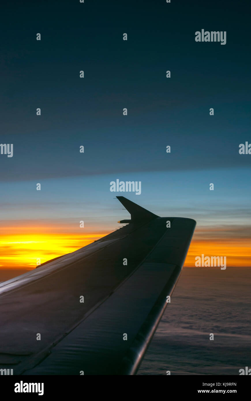 Sunset above clouds seen from airplane window Stock Photo - Alamy