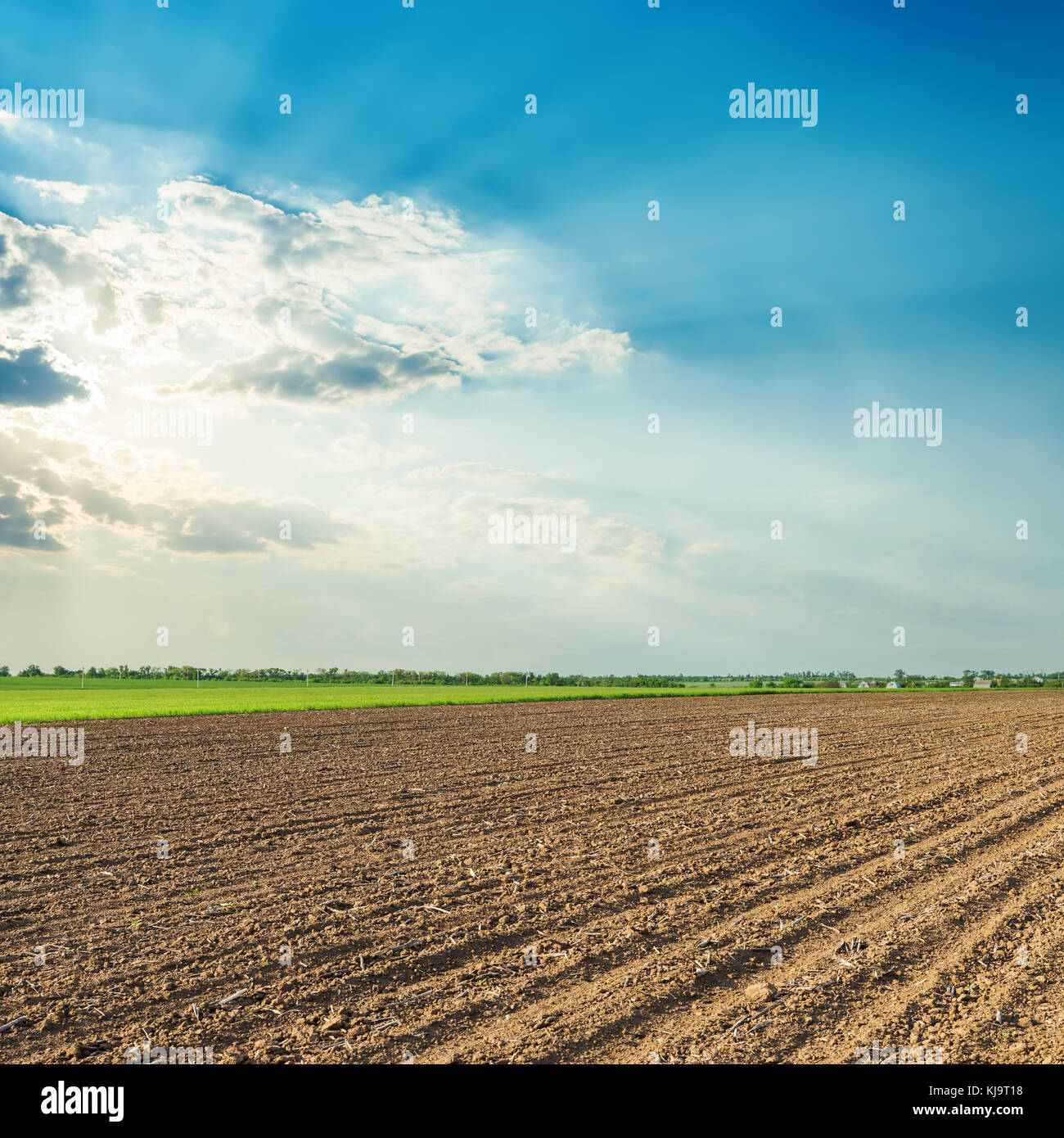 sun in clouds over black agriculture field Stock Photo - Alamy