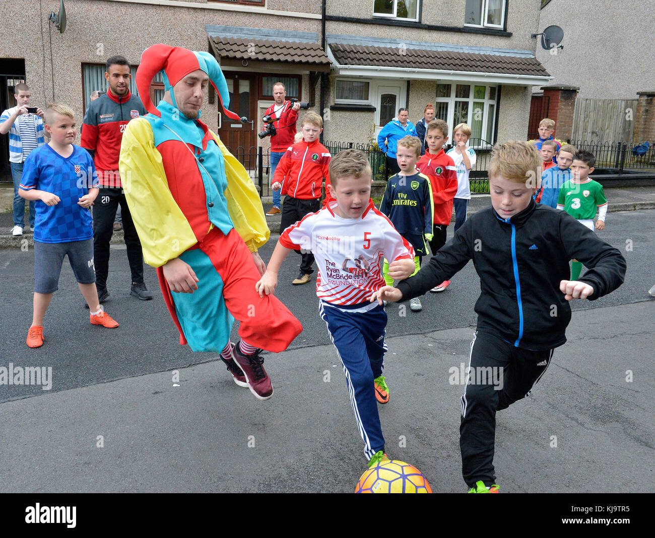 Children play football, in the street, with clown, Londonderry ...