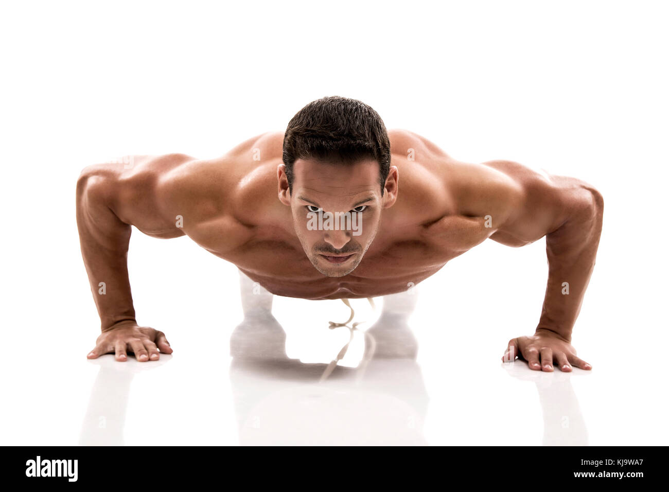 Muscle man making pushups in studio, isolated over a white background ...