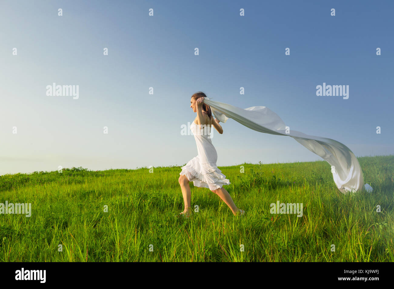 Young beautiful woman running while holding a white tissue Stock Photo ...