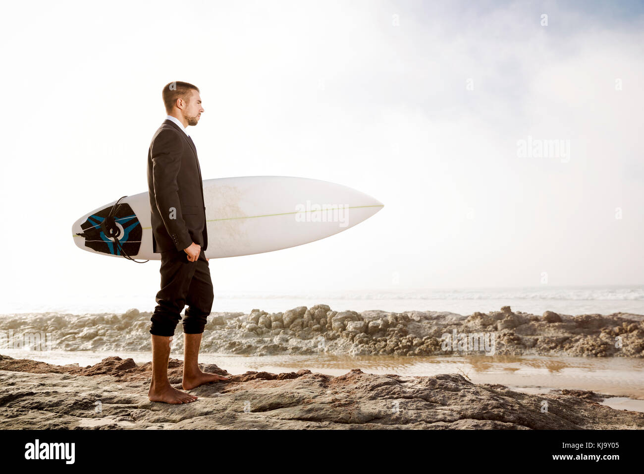 A Businessman holding is surfboard after a long day of work Stock Photo ...