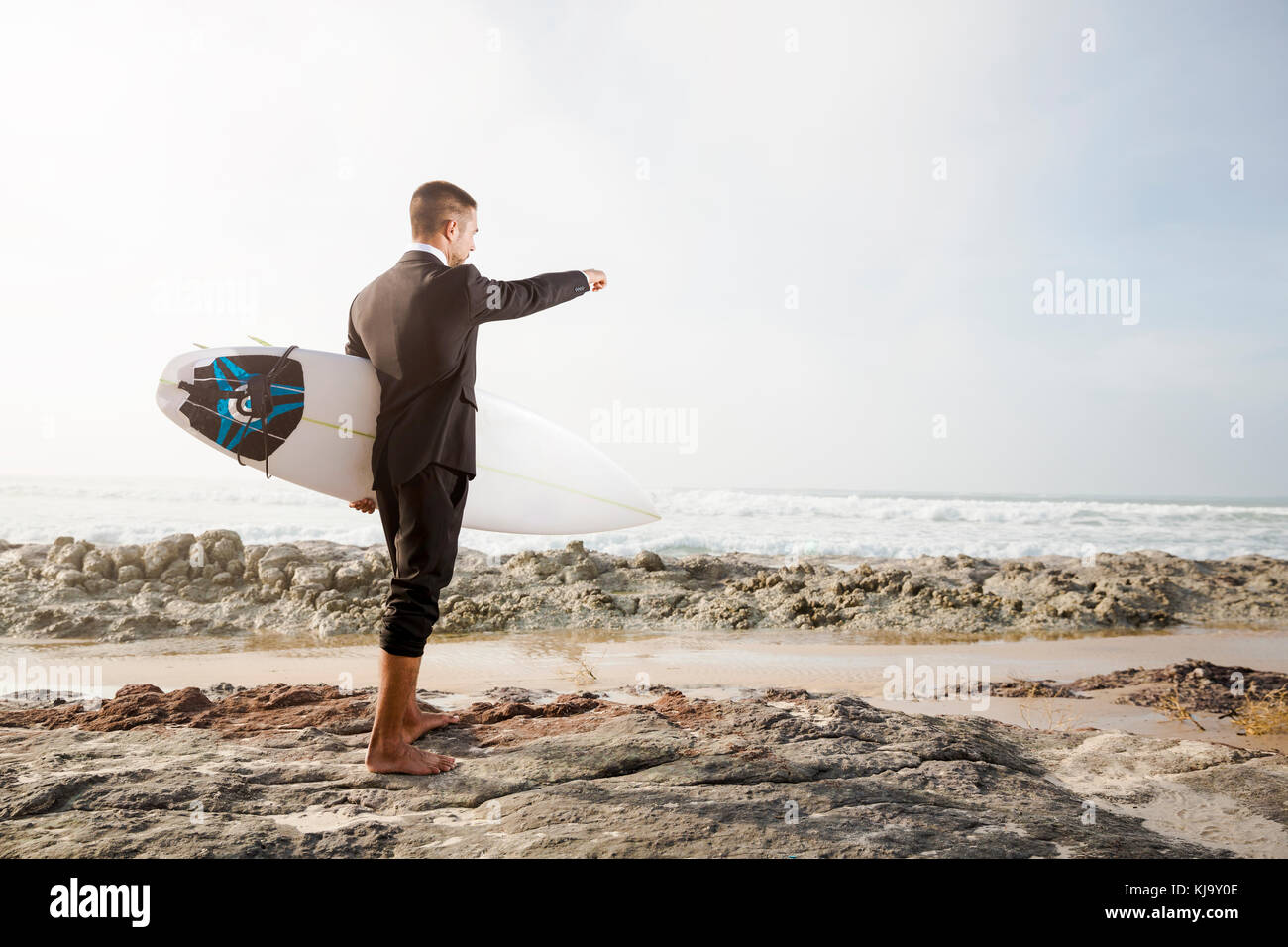 A Businessman holding is surfboard after a long day of work Stock Photo ...