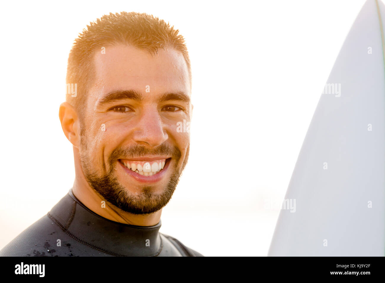 Outdoor portrait of an handsome young surfist smiling Stock Photo - Alamy
