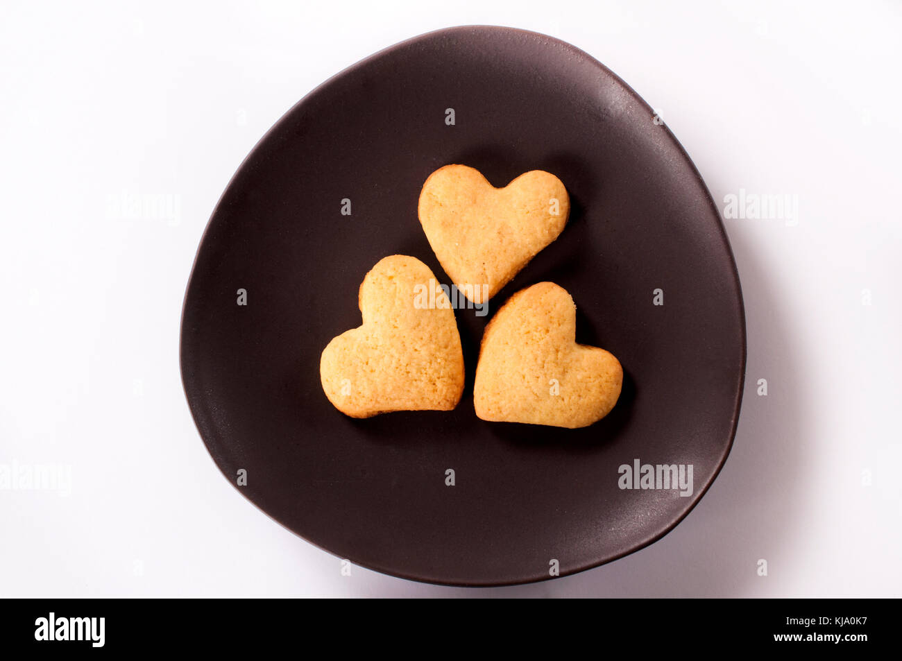 Three heart shape cookies in the plate on white backgound Stock Photo ...