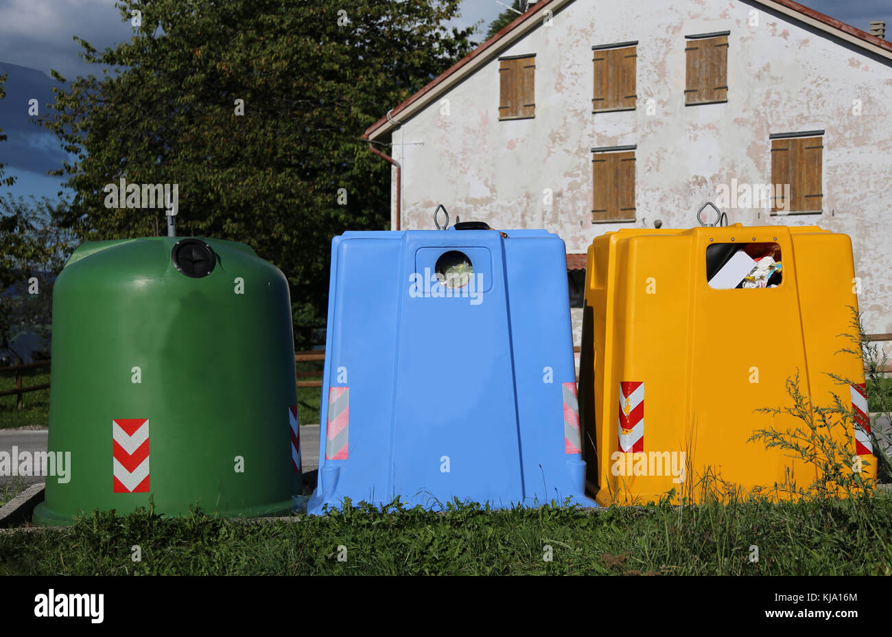 three large waste bin collectors in the city Stock Photo - Alamy