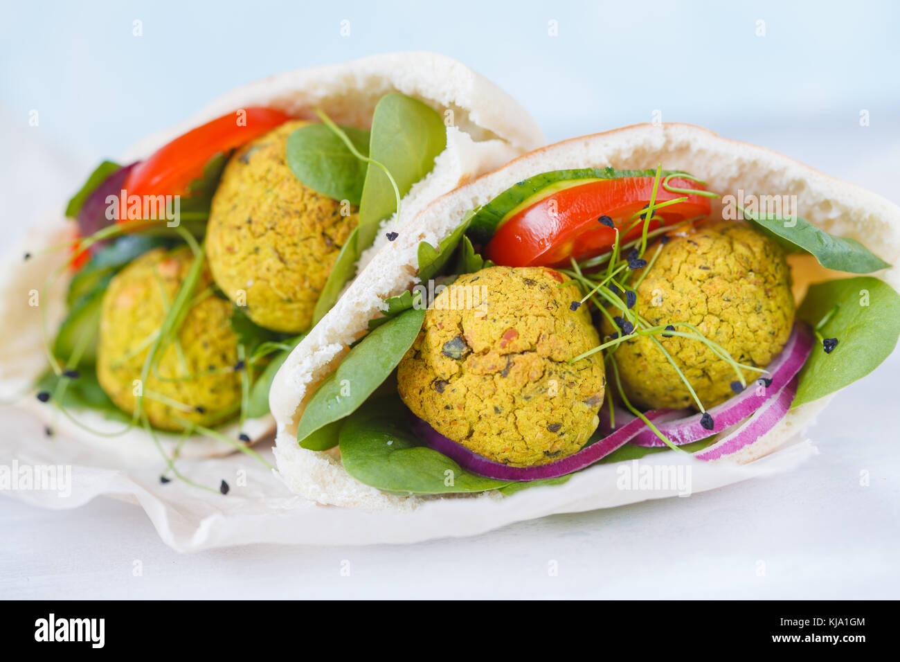 Baked falafel and fresh vegetables in pita bread, light background ...