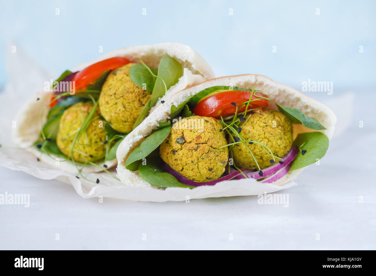 Baked falafel and fresh vegetables in pita bread, light background ...